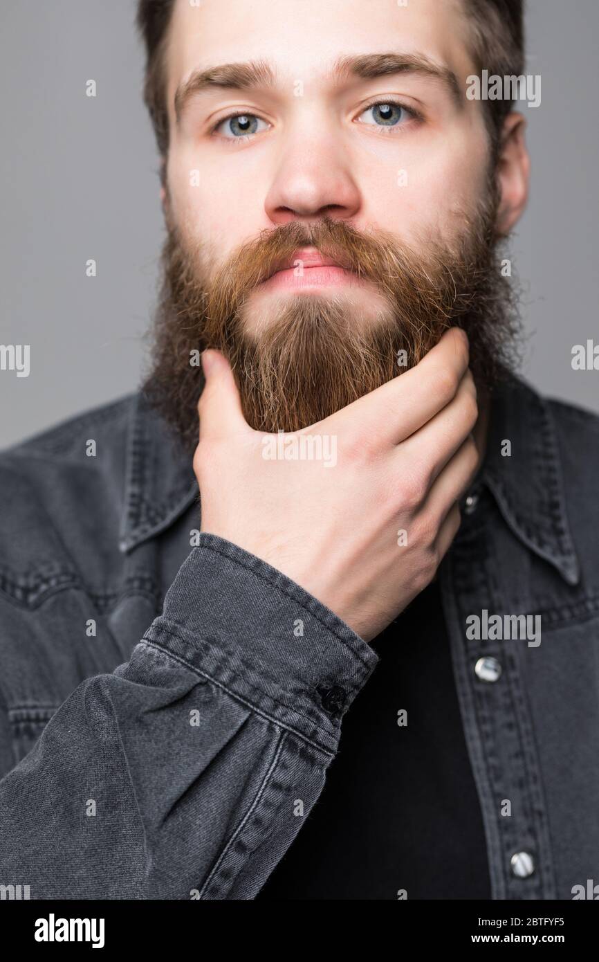 portrait of thinking stylish young man touch his beard Stock Photo - Alamy