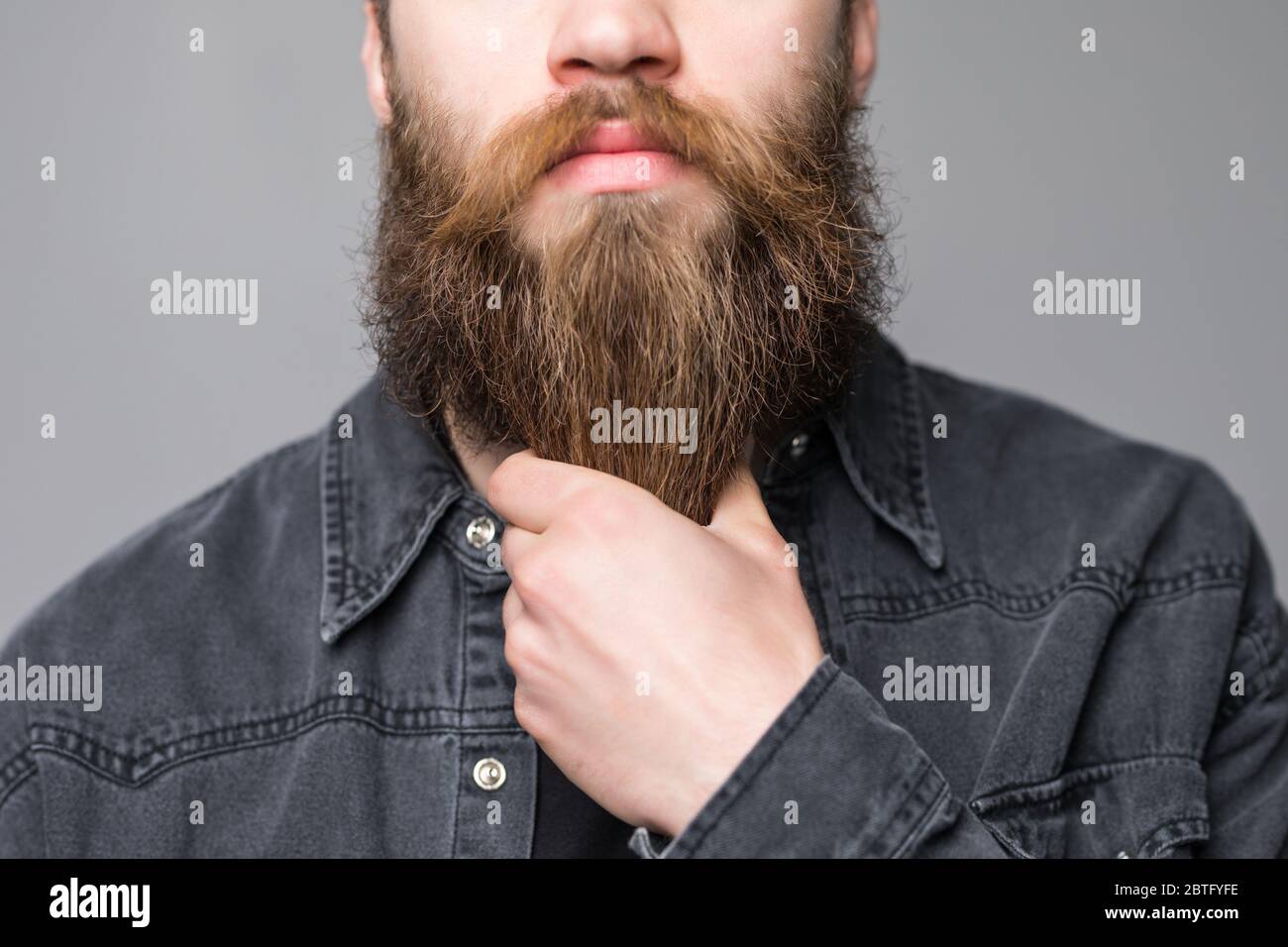 Touching his perfect beard. Close-up of bearded man touching his beard ...