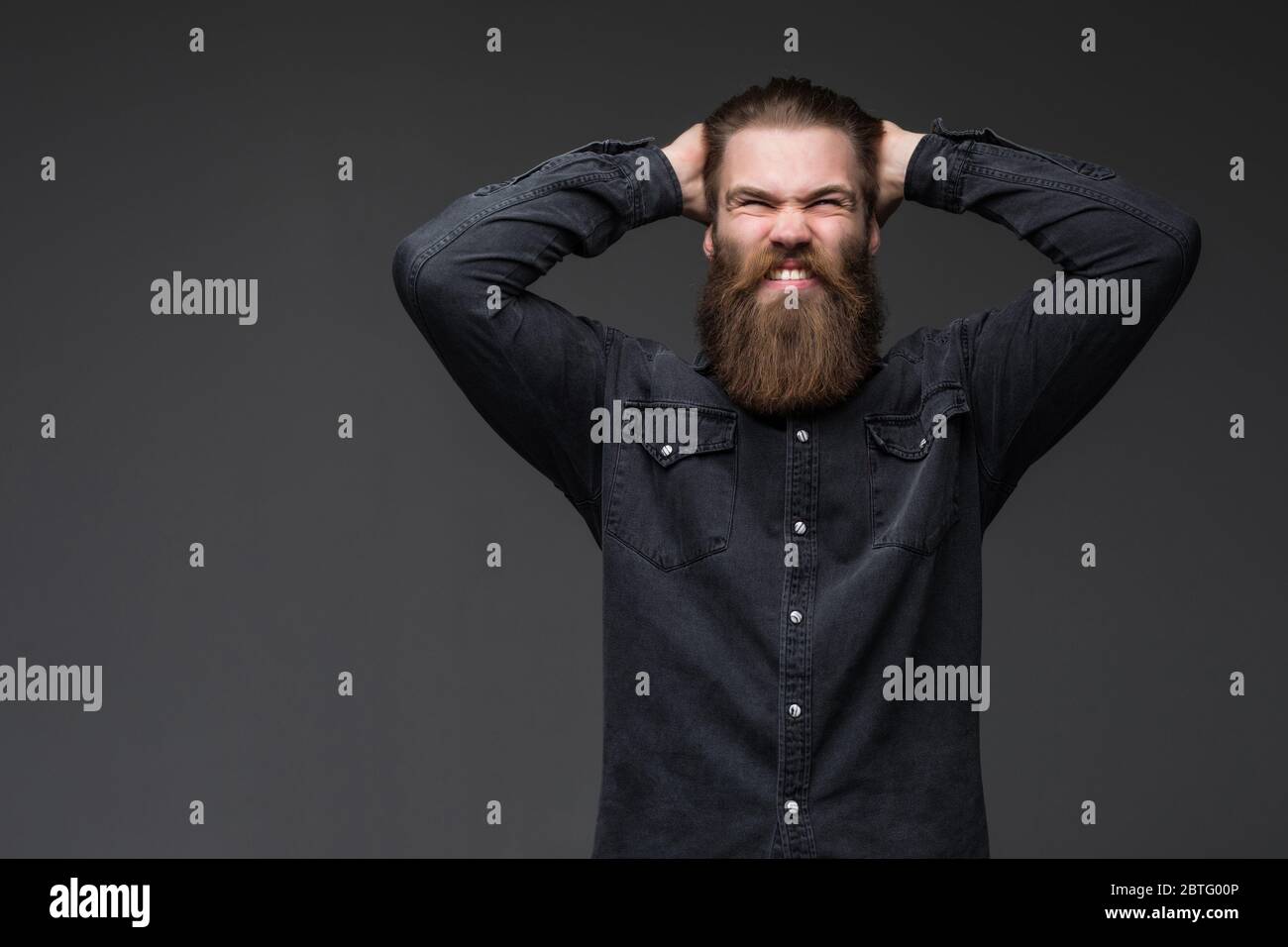 Bearded man in rage shouting loudly with mouth opened on gray ...