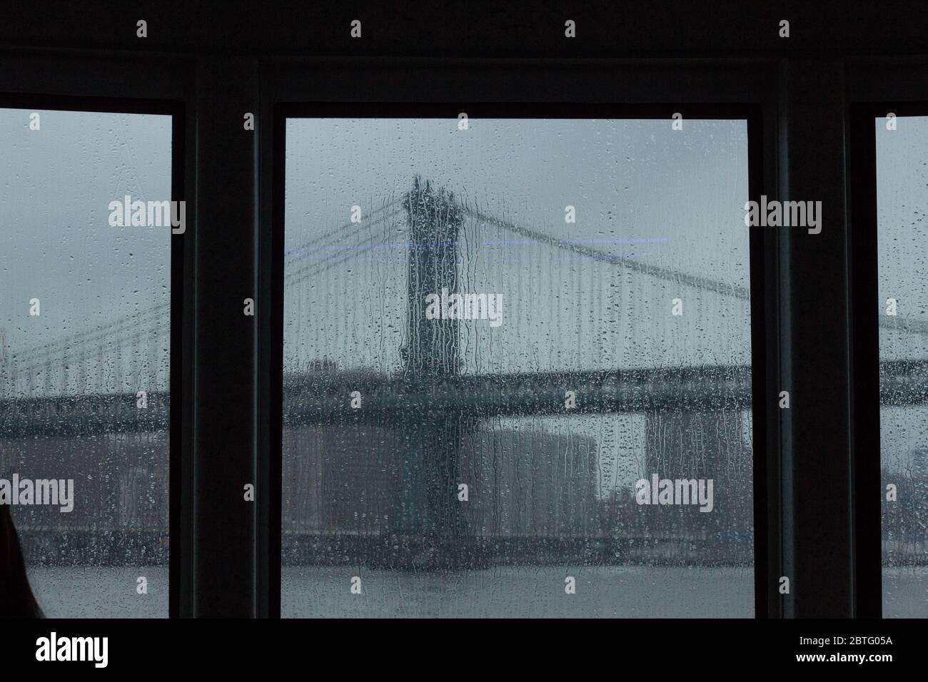 The Brooklyn Bridge seen through a window on a grey rainy day Stock ...