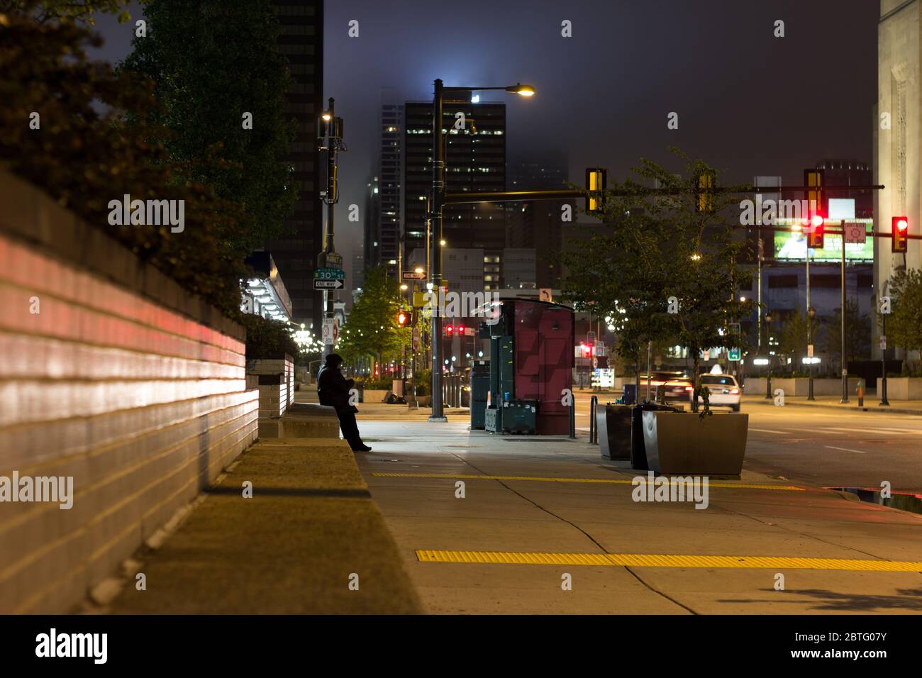 A woman waits alone in the Philadelphia city centre at night Stock ...