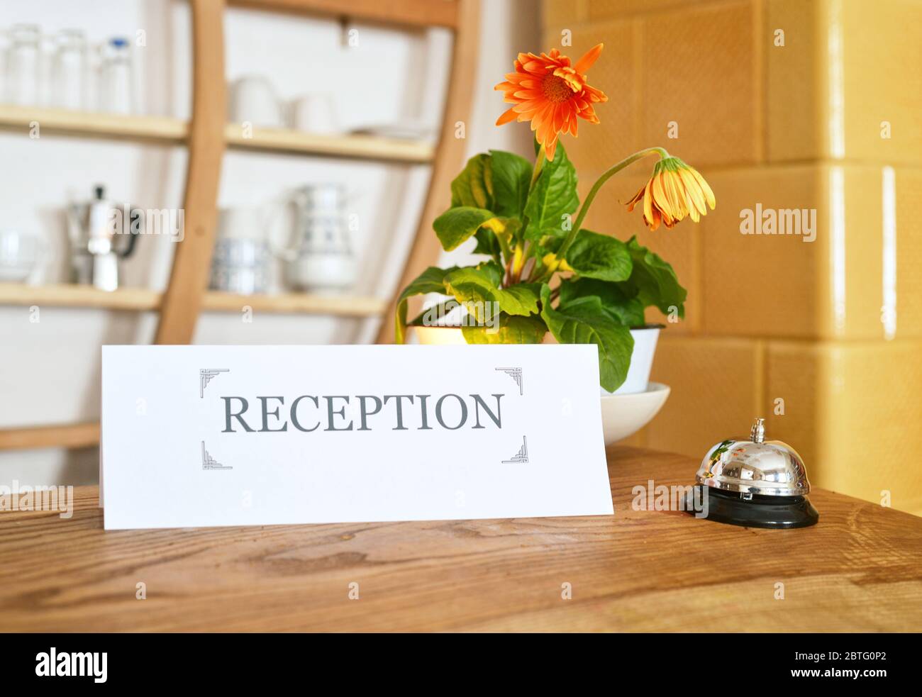 friendly reception counter with flowers and bell Stock Photo - Alamy