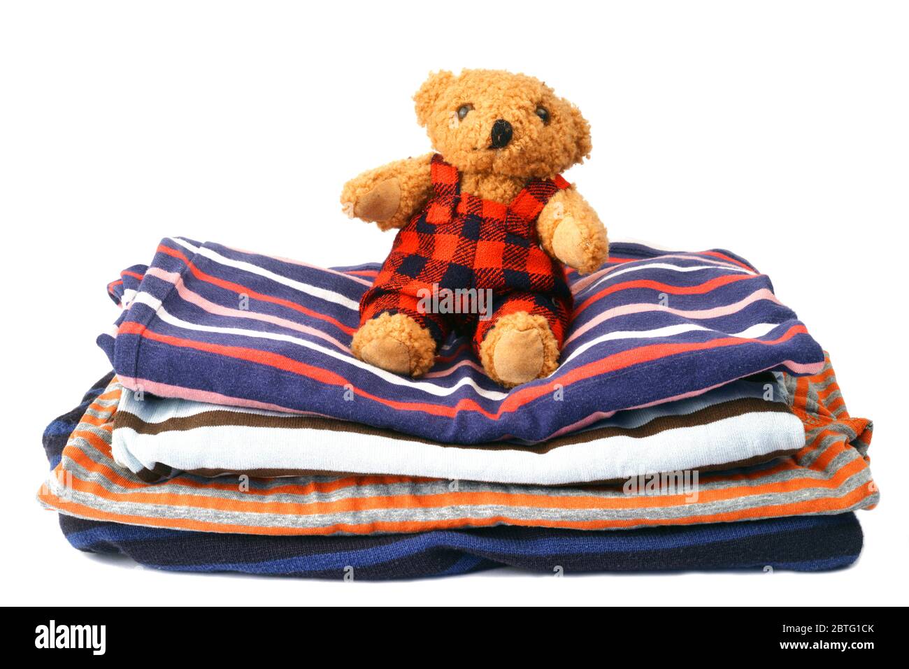 single Teddy sitting on child clothes Stock Photo - Alamy