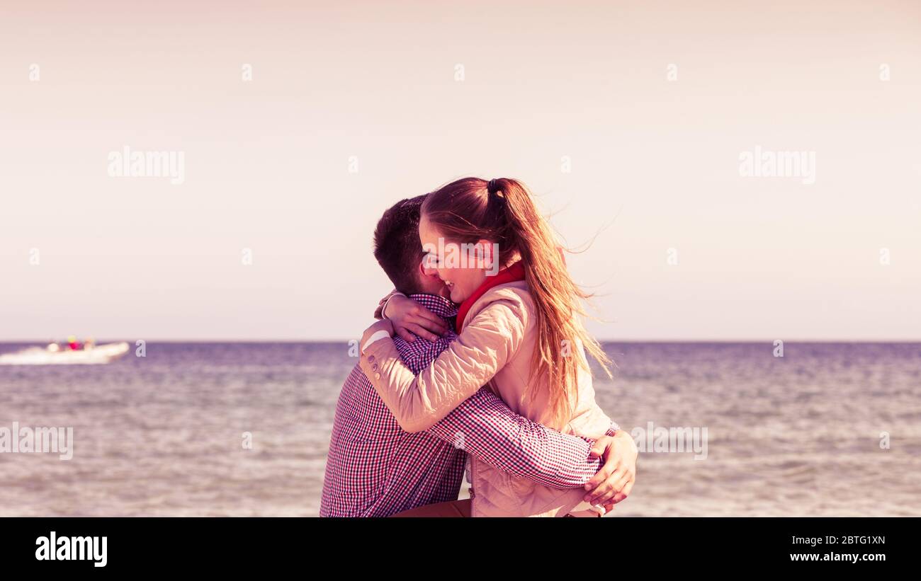 loving couple spending leisure time together at beach hugging side view ...