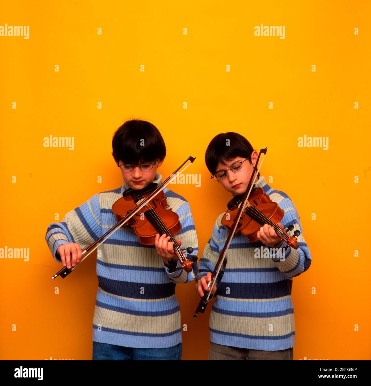 Twins, aged 10 playing violins Stock Photo - Alamy
