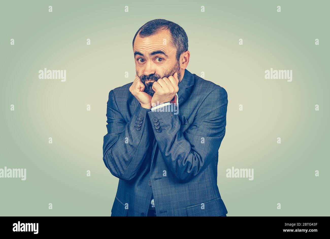 Portrait anxious middle aged bearded man biting his nails fingers ...