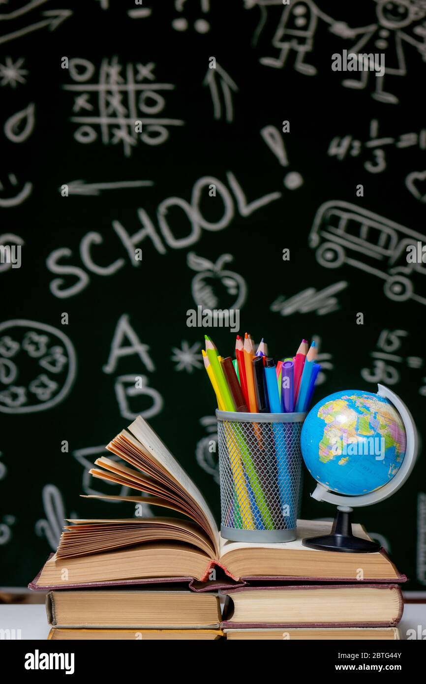 Back to school background with books, pencils and globe on white table ...