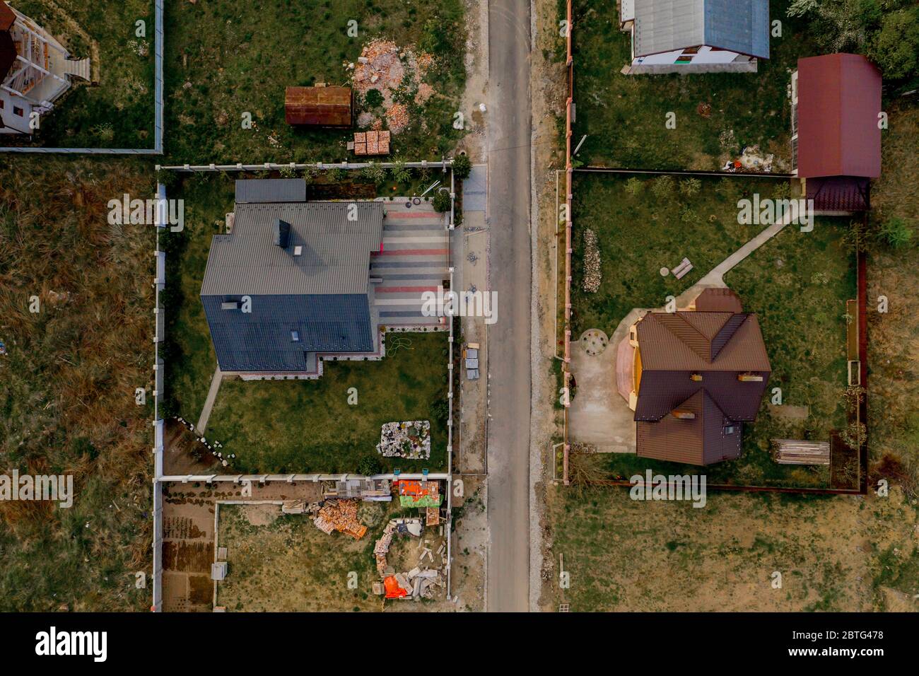 Aerial top view of a house with paved yard with green grass lawn with ...