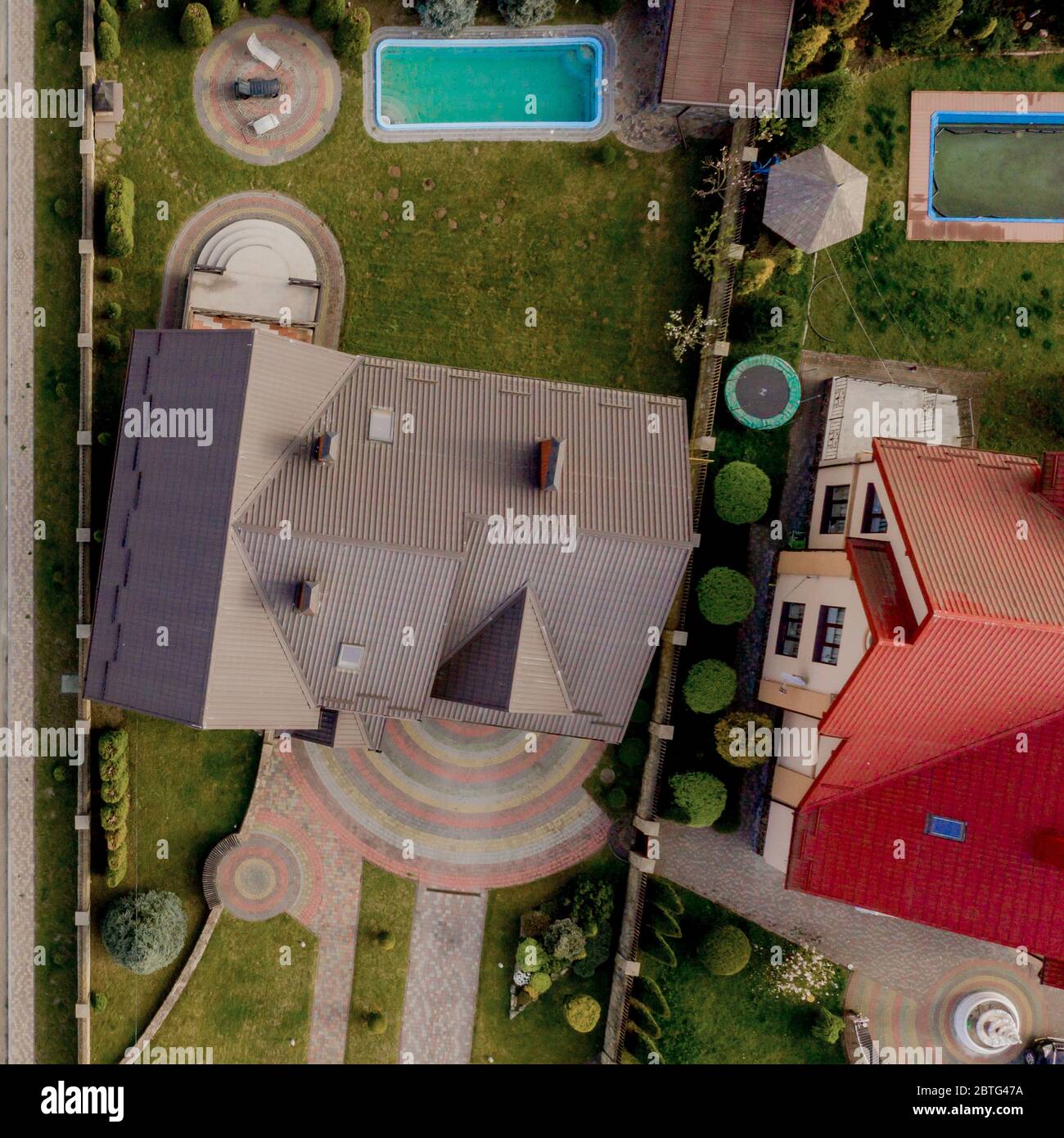 Aerial top view of a private house with paved yard with green grass ...
