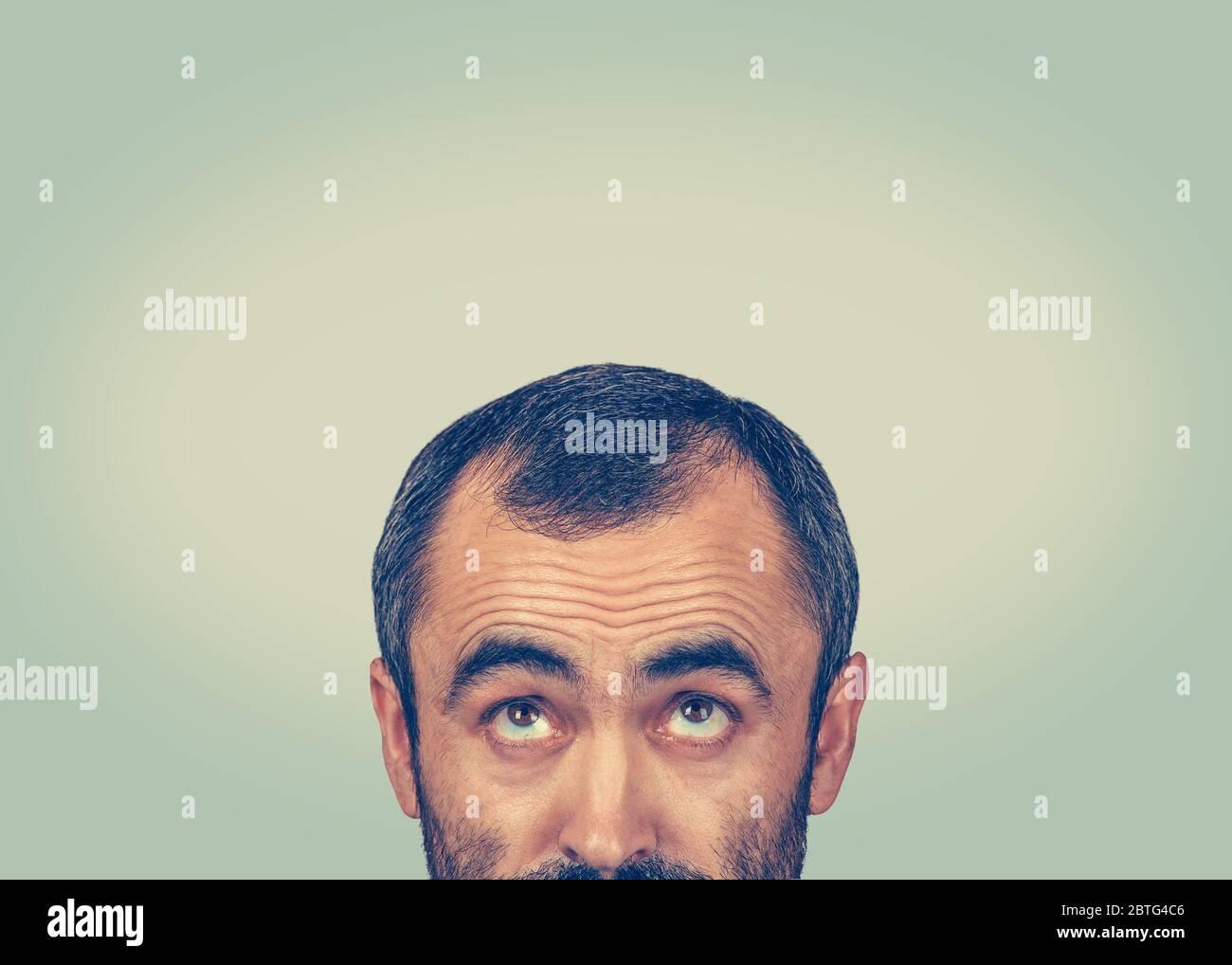 Headshot confused man thinking looking up isolated on green yellow ...