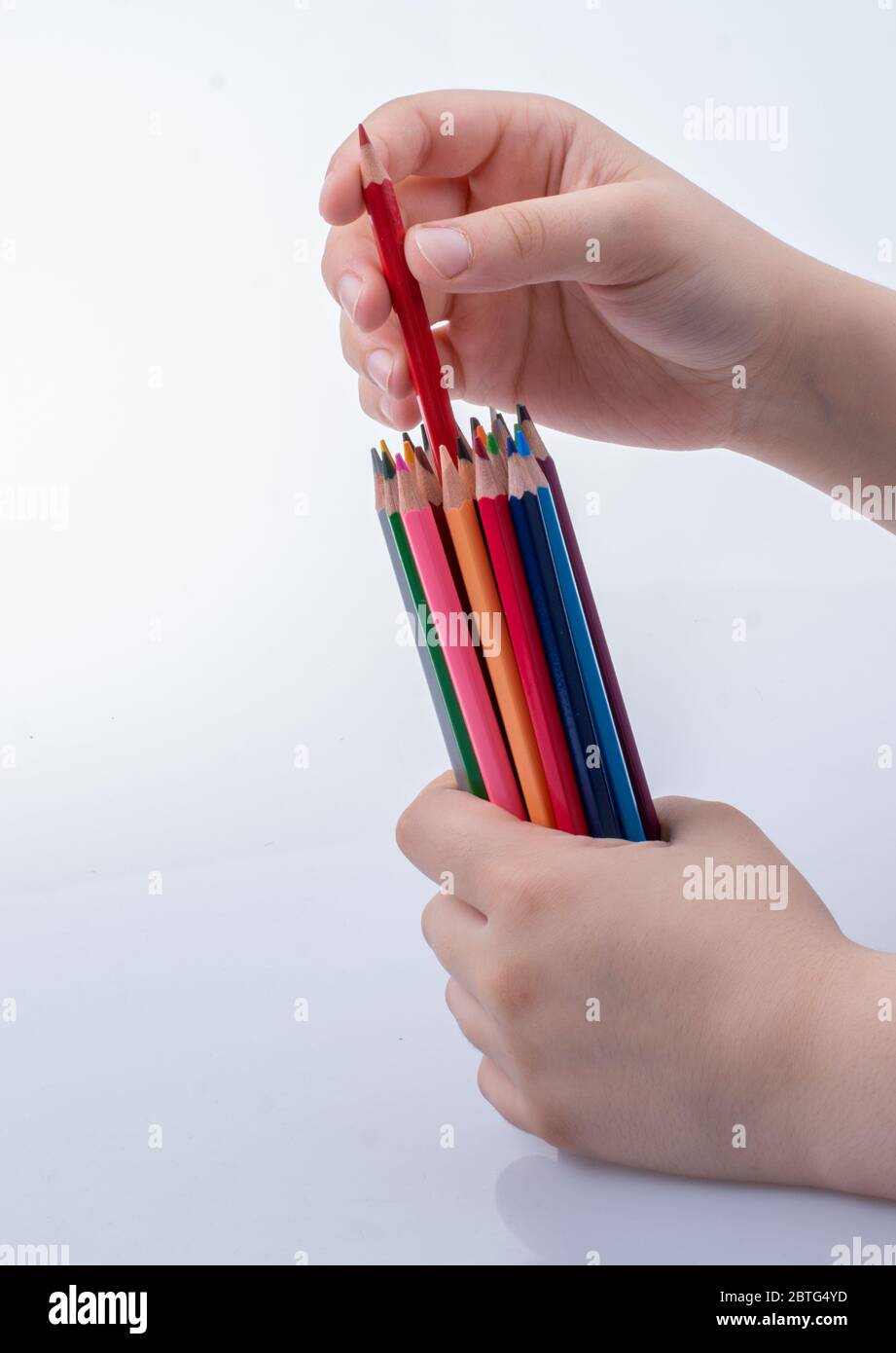 Hand holding color Pencils placed on a white background Stock Photo - Alamy