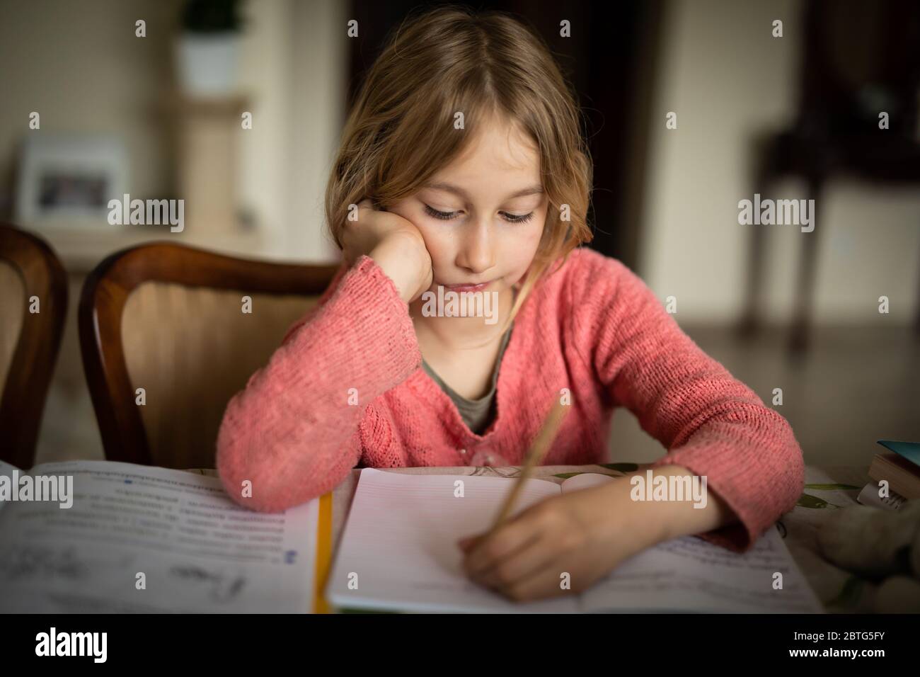 lefthanded girl writting homeworks during covid-19 lockdown ...
