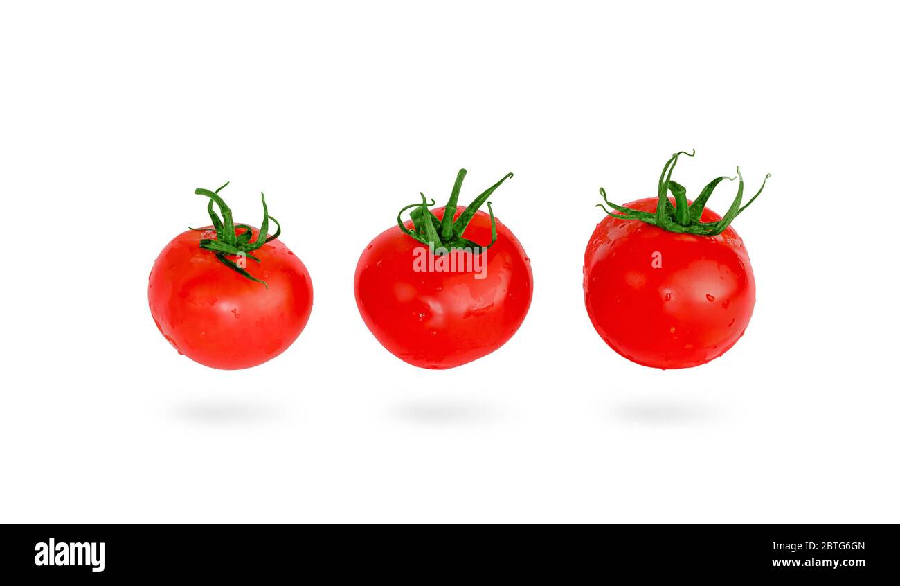 Three floating tomatoes isolated on white background Stock Photo - Alamy