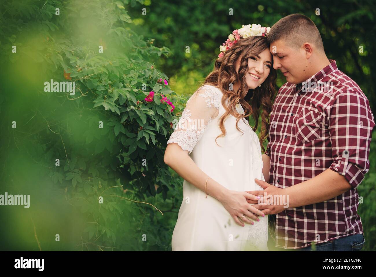 Pregnant girl and her husband are happy to hug, hold hands on stomach ...