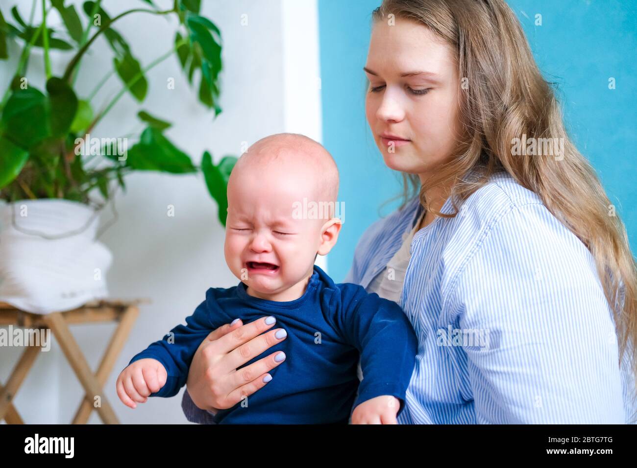 Mom hugs crying moody kid tantrum. Little baby child on mother hands ...