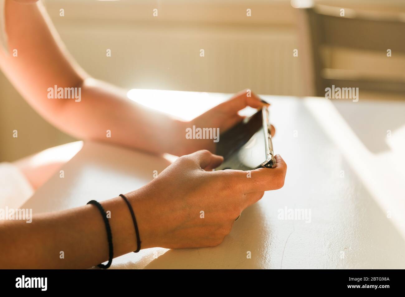 Hands holding a mobile phone in landscape mode whilst playing video ...