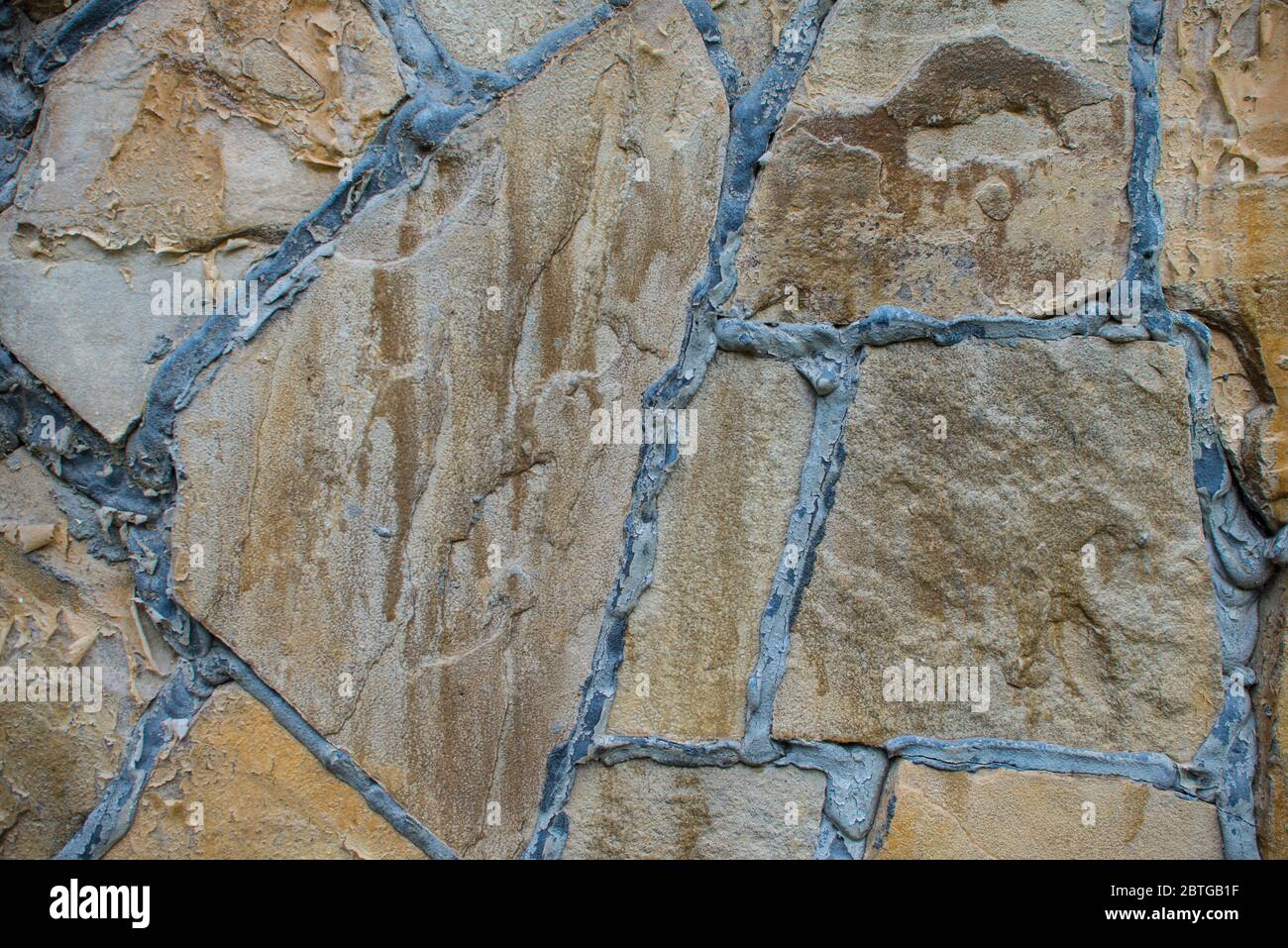 Natural brown stone block paving texture. Stone wall with black seams ...
