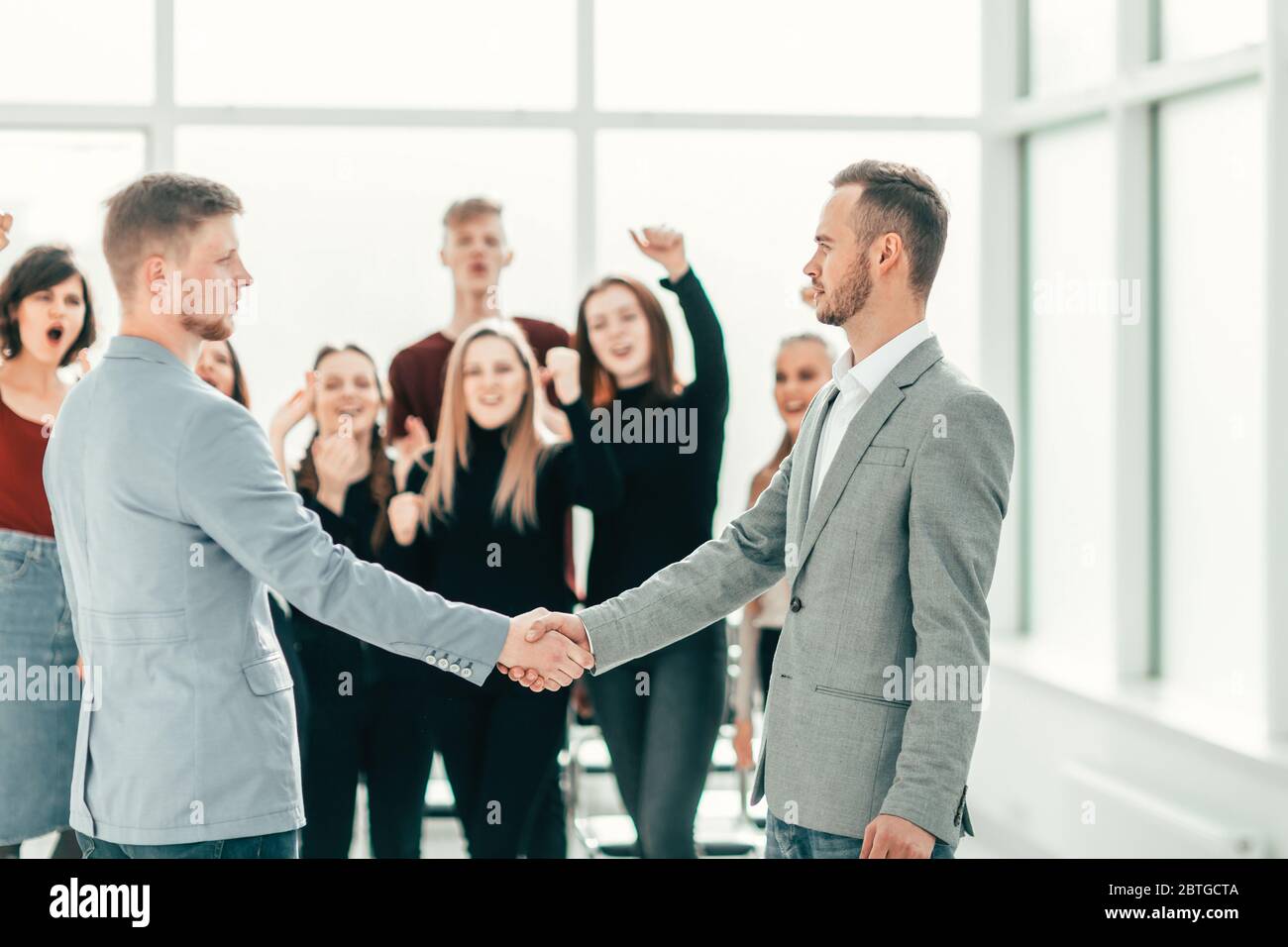 serious young men shaking hands. concept of cooperation Stock Photo - Alamy