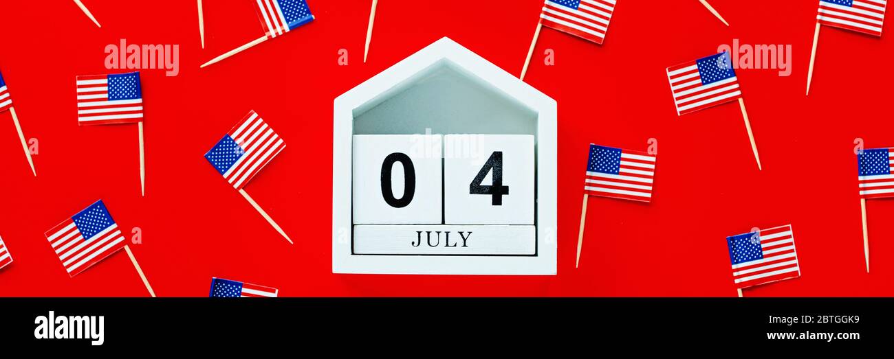 July 4th. Mockup of july 4 wooden color calendar and USA flags on red ...