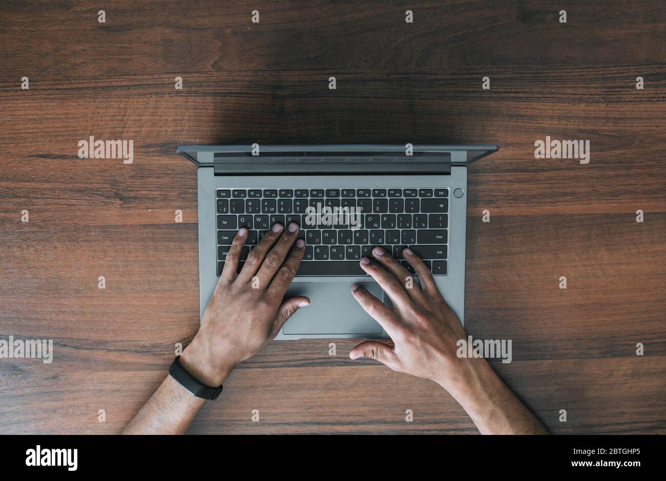 Men's hands in an electronic watch on a laptop keyboard Stock Photo - Alamy
