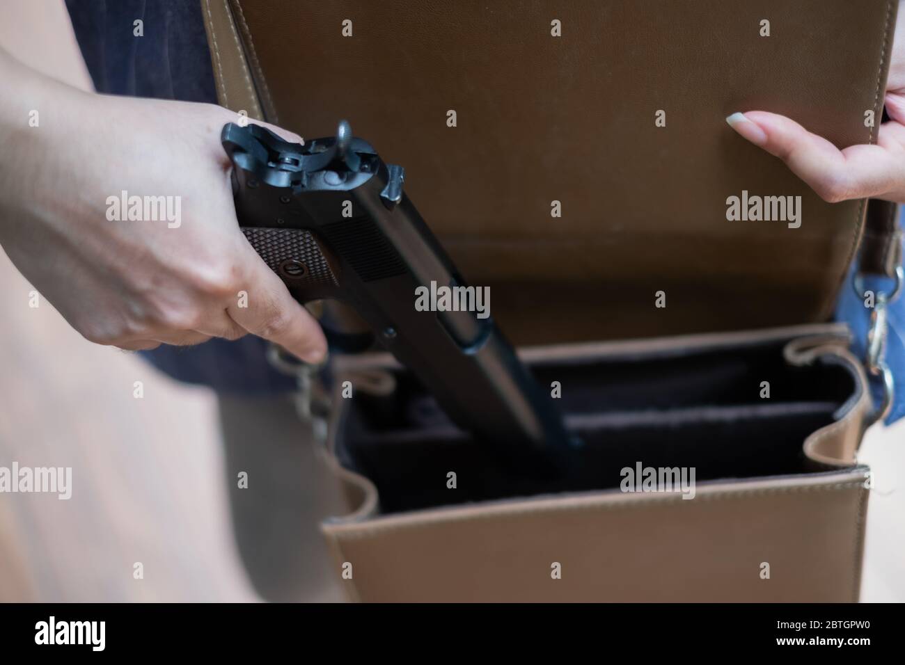 Young Asia woman putting a gun in her handbag, Women hand pulling a ...