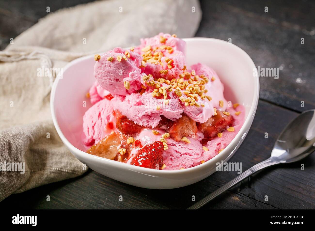 Strawberry sorbet with jam, berries and puffed rice in a white bowl ...