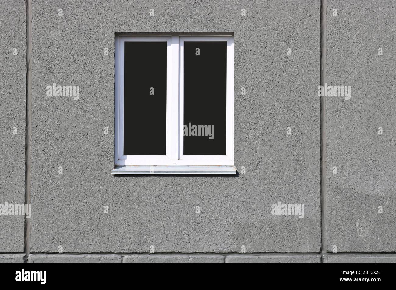 A double-hung window in the concrete slab of the new house. The texture ...
