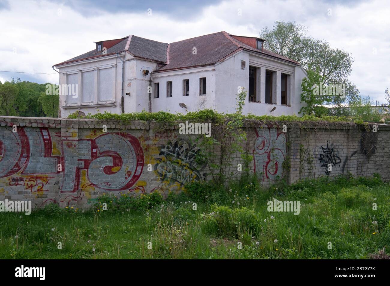 An old mansion, now closed, decaying and rotting, next to a graffiti ...