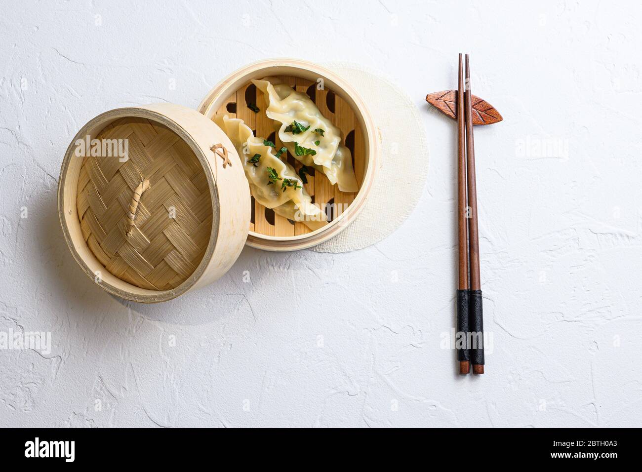 steamed dumpling in traditional wooden steamer on white texture stone ...