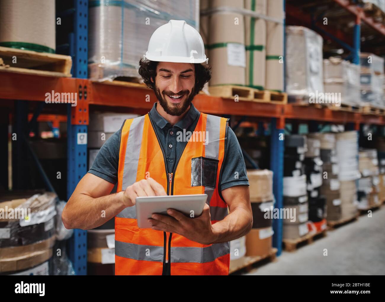 Successful entrepreneur in warehouse checking inventory list using ...