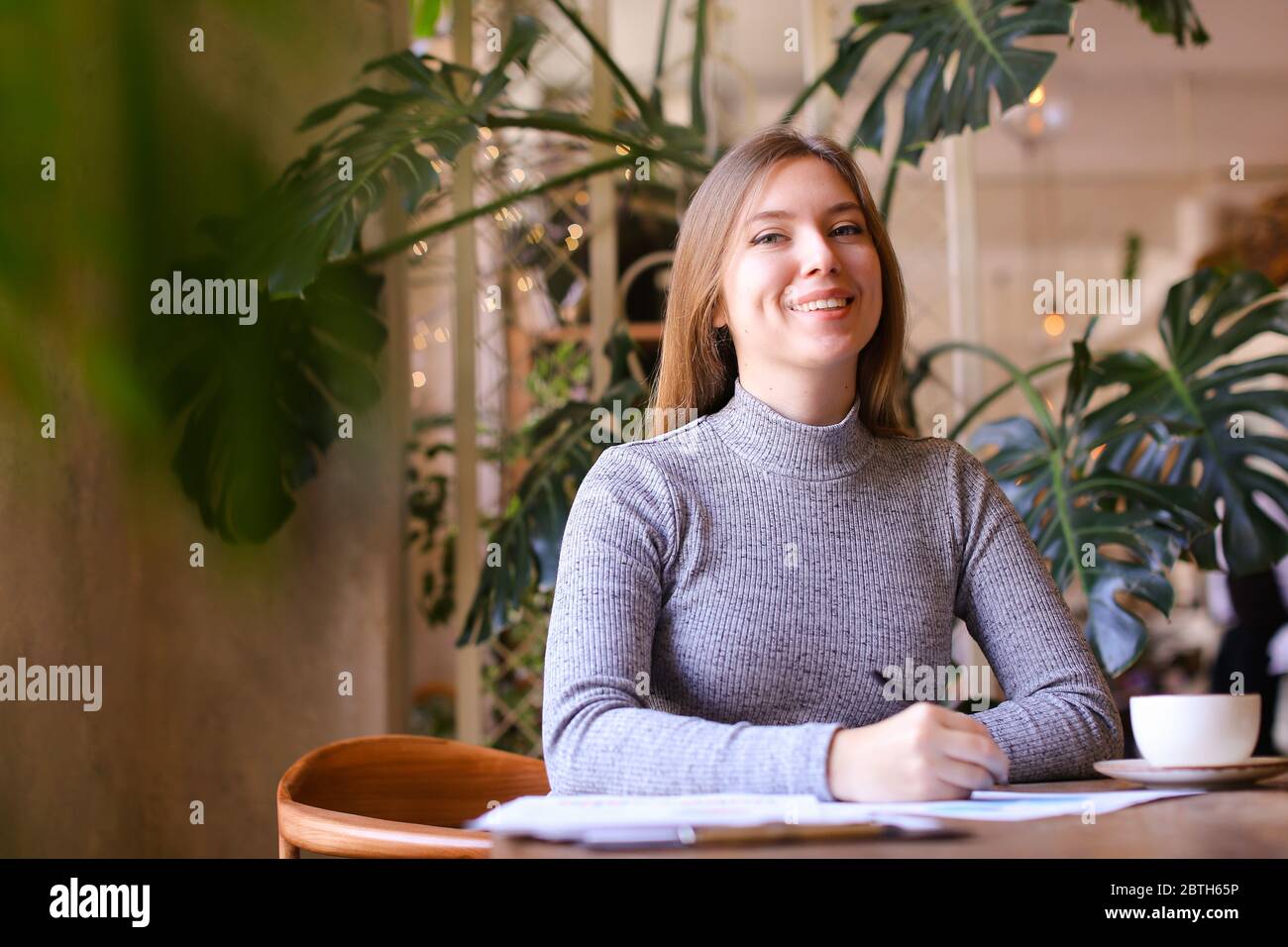 Young female student taking notes into notebook in class room Stock ...