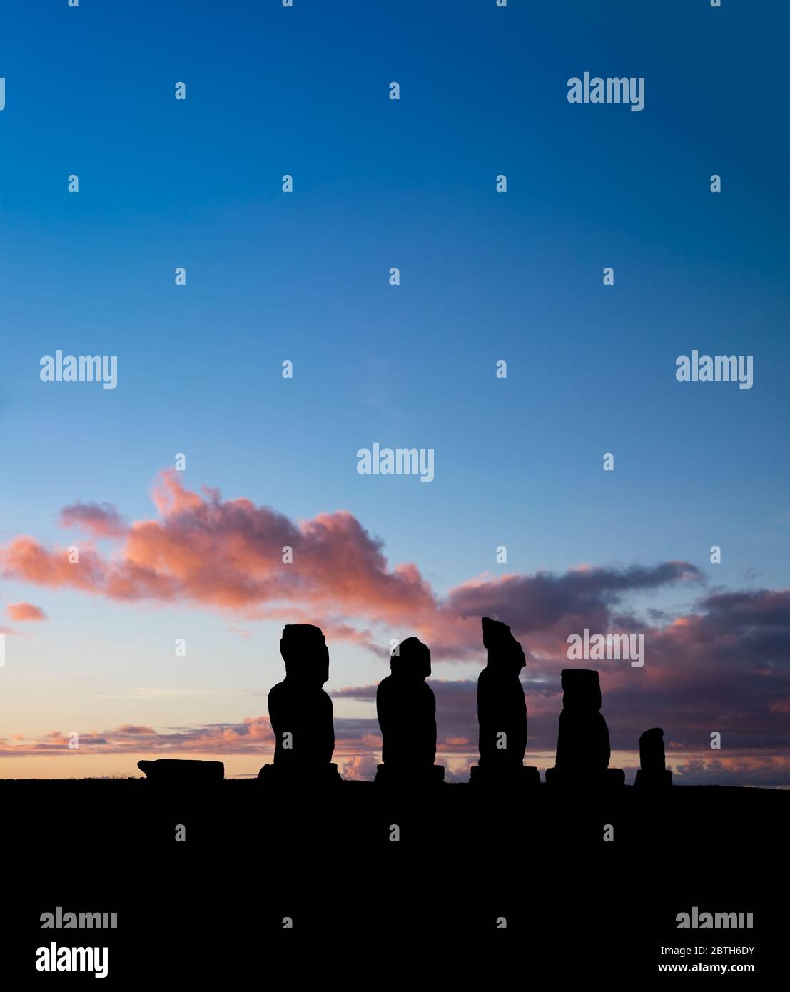 Beautiful high contrast sunset with moais in a row Stock Photo - Alamy