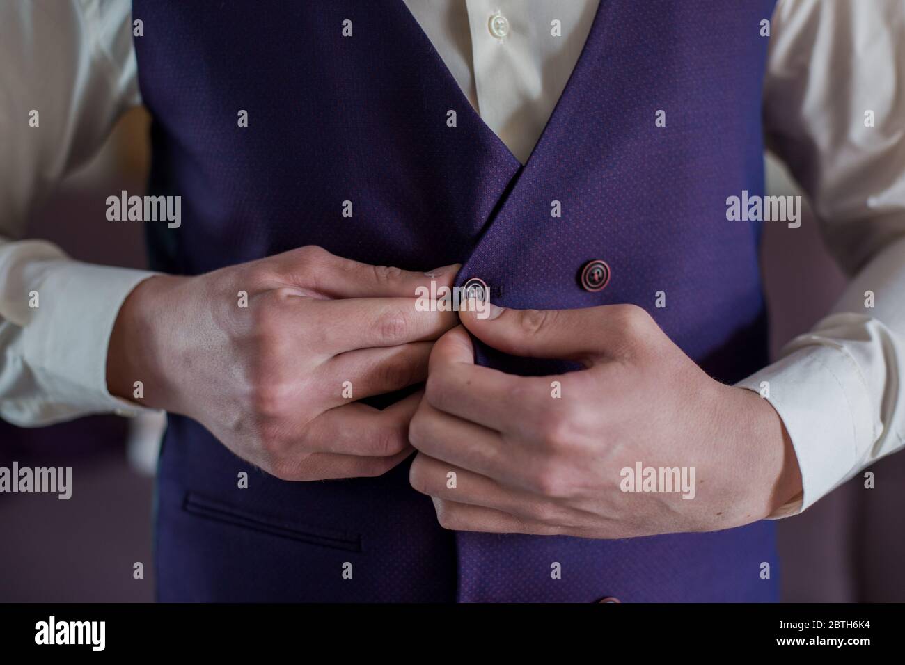 man puts on suit in the room Stock Photo - Alamy