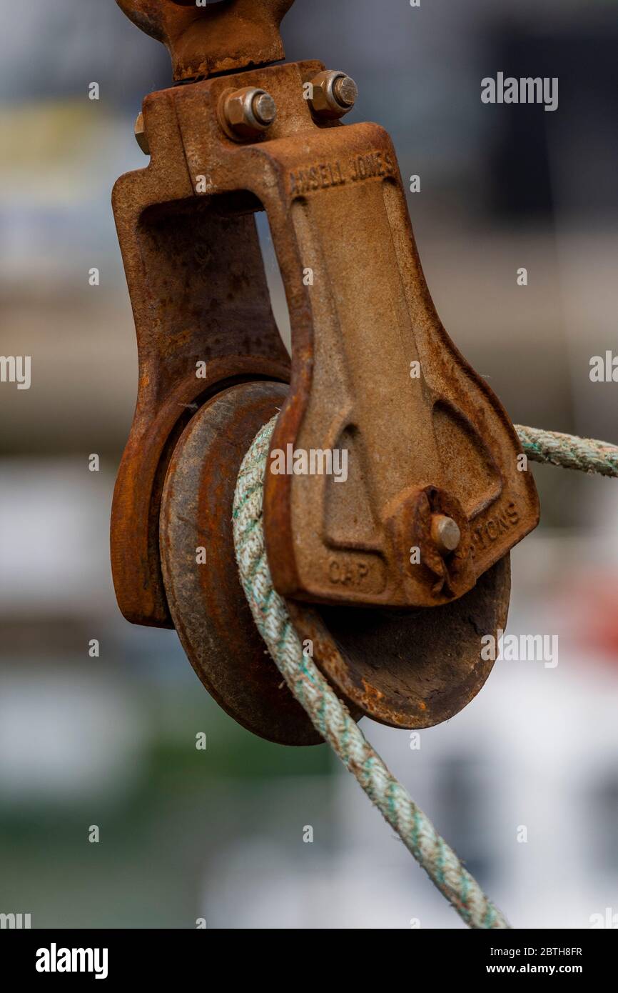 a rusty and corroded old pulley block and wire rope on a fishing ...
