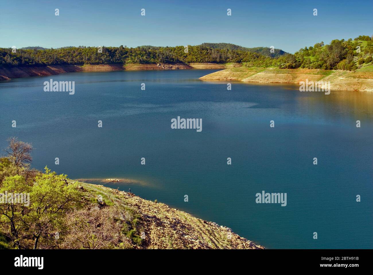 Low water level at New Melones Lake on Stanislaus River, man fishing ...