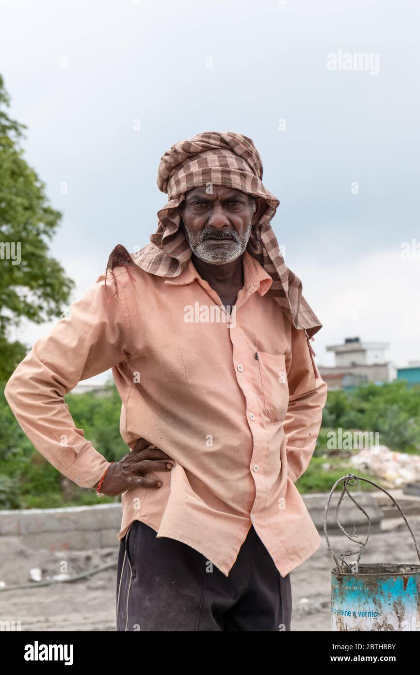 Portrait of a man working at the construction site of bridge, Ghaziabad ...