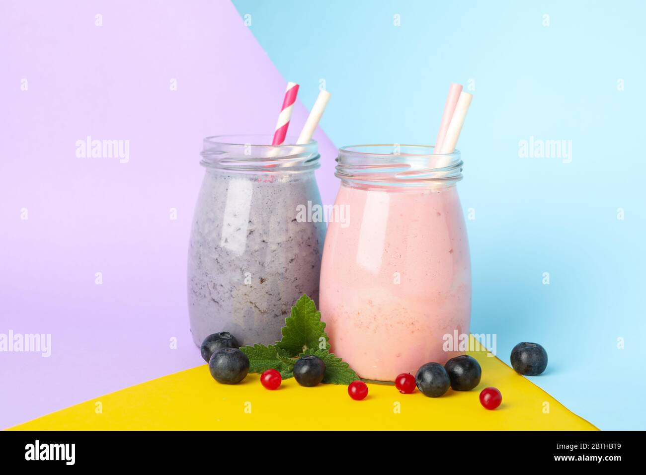 Glasses of berry milkshake on two tone background. Summer drink Stock ...