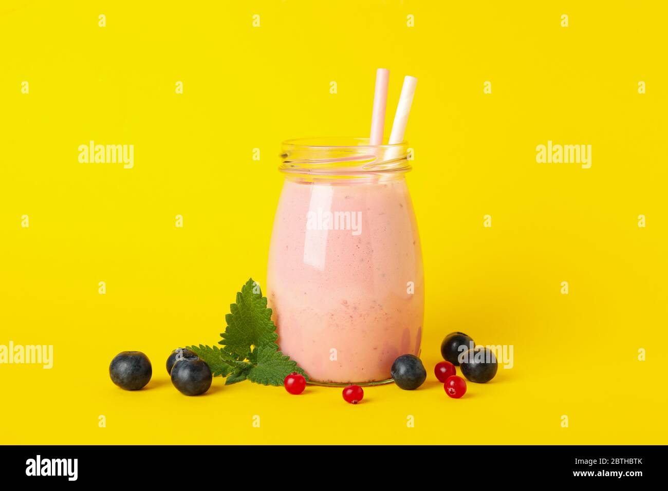 Delicious berry milkshake on yellow background. Summer drink Stock ...