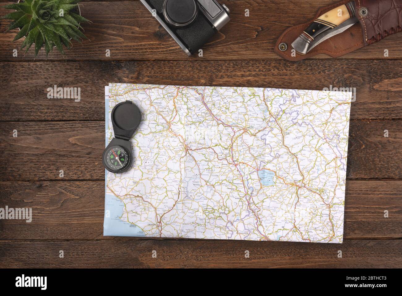 Top view travel concept with retro camera, map, knife and compass on ...