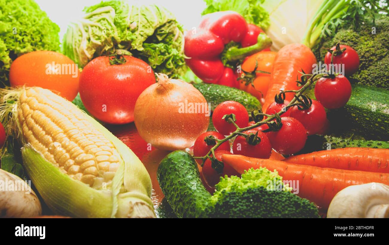 Toned photo of wet washed vegetables from garden over white background ...