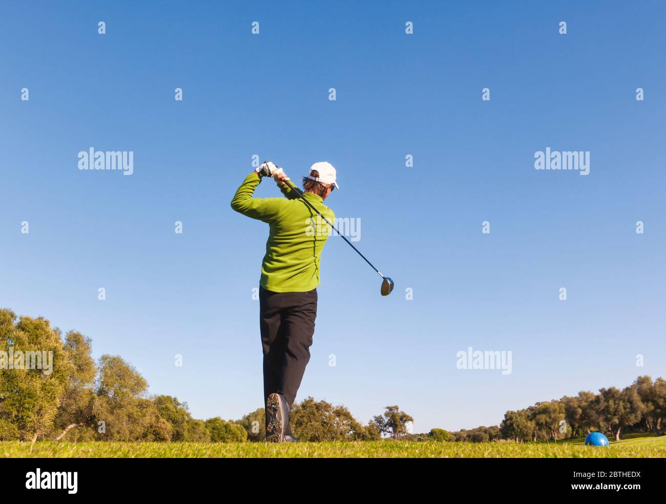 Male golfer at end of swing with driver Stock Photo - Alamy