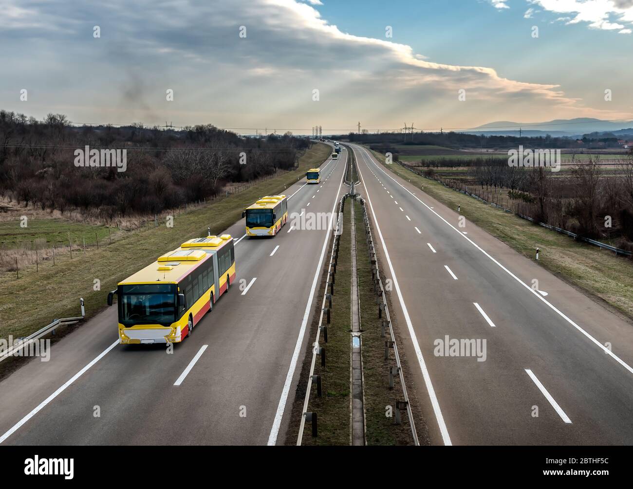 Intercity Yellow Line Buses in line traveling on a rural country ...