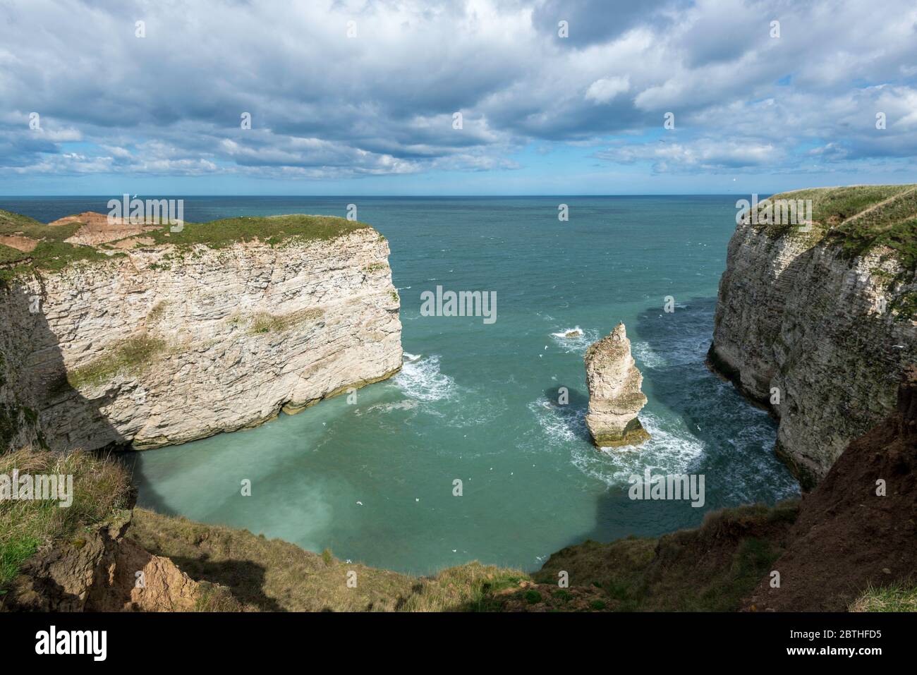 White chalk cliffs and a sea stack in a small cove near Flamborough ...