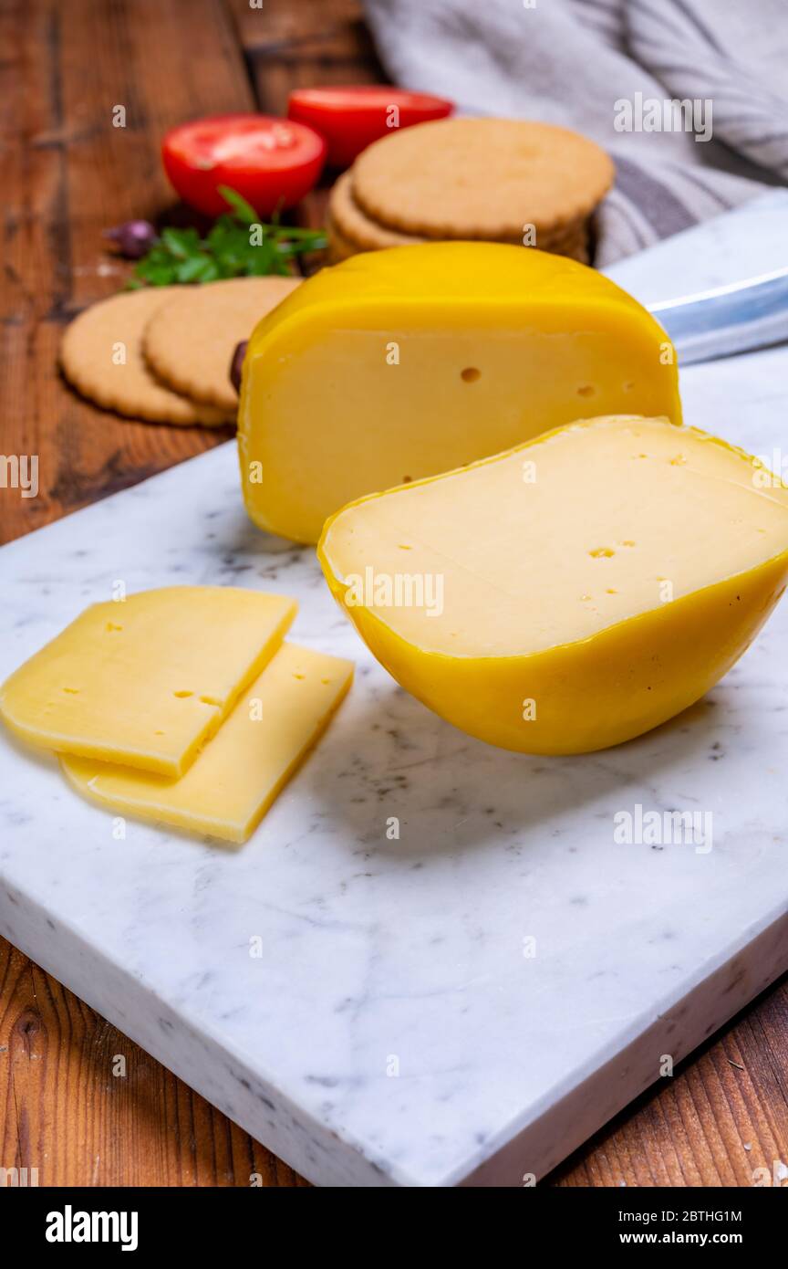 Dutch baby gouda cheese in yellow wax close up Stock Photo - Alamy