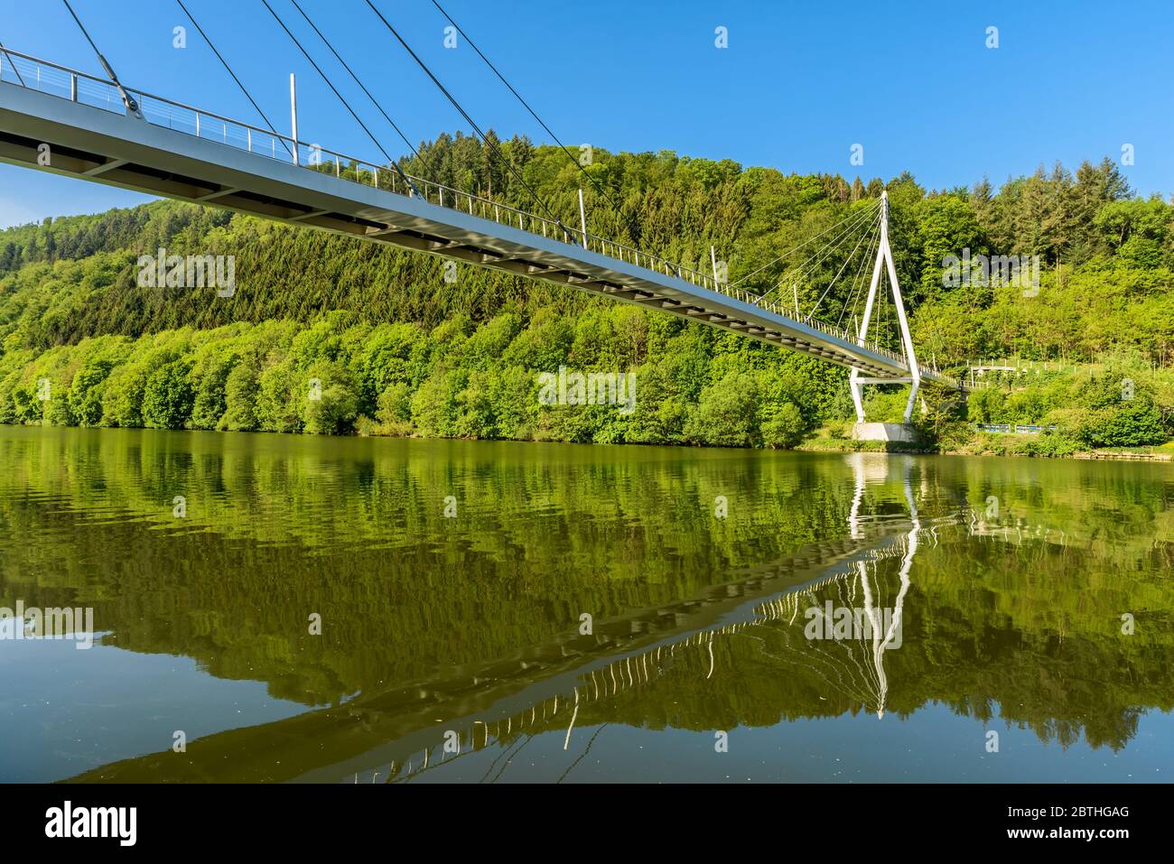 Bridge and banks of the Neckar river reflecting in water, Zwingenberg ...