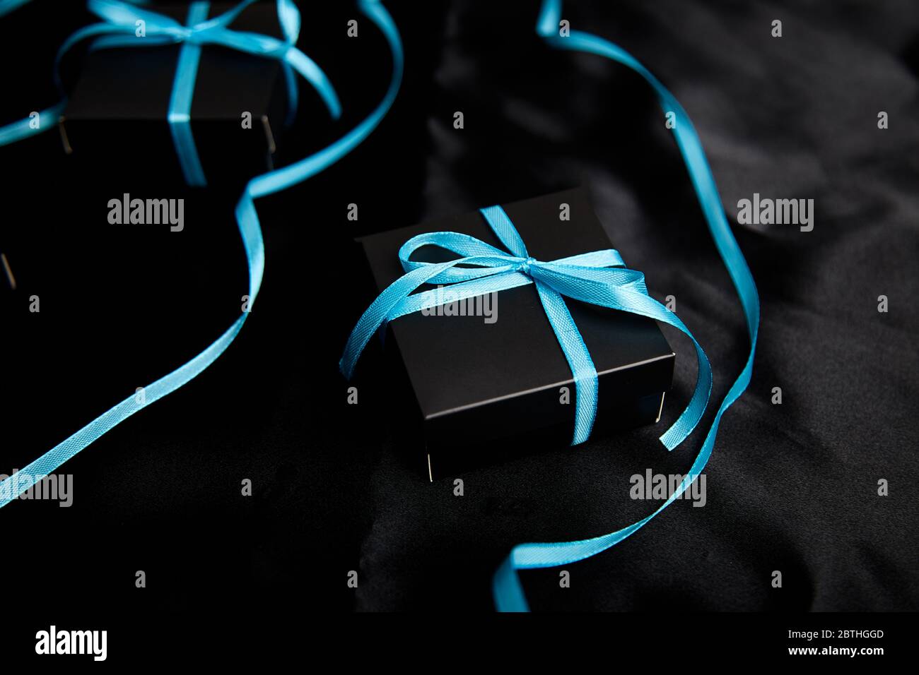 Luxury black gift boxes with blue ribbon Stock Photo - Alamy