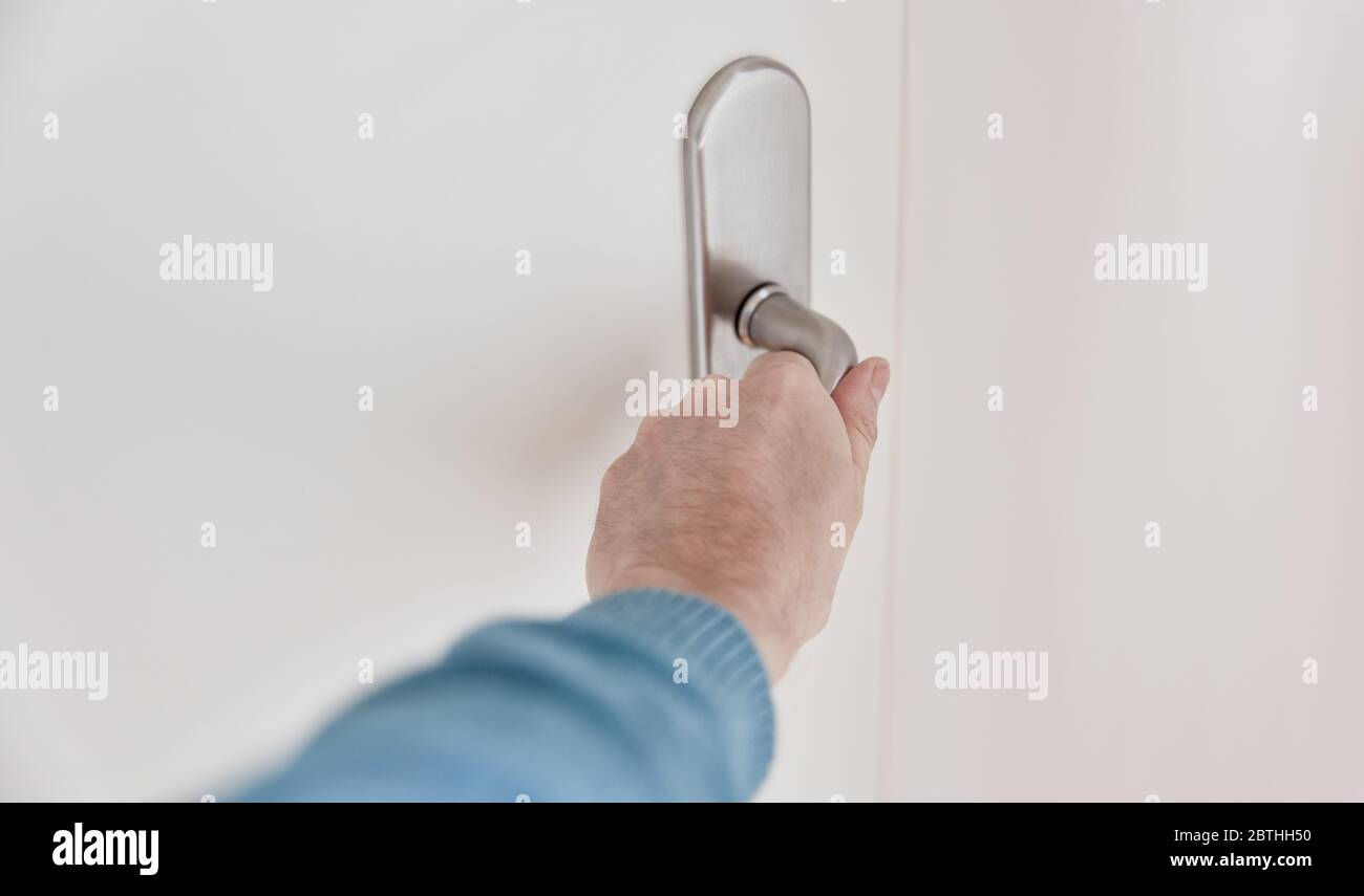Hand on handle when opening the door in an apartment Stock Photo - Alamy