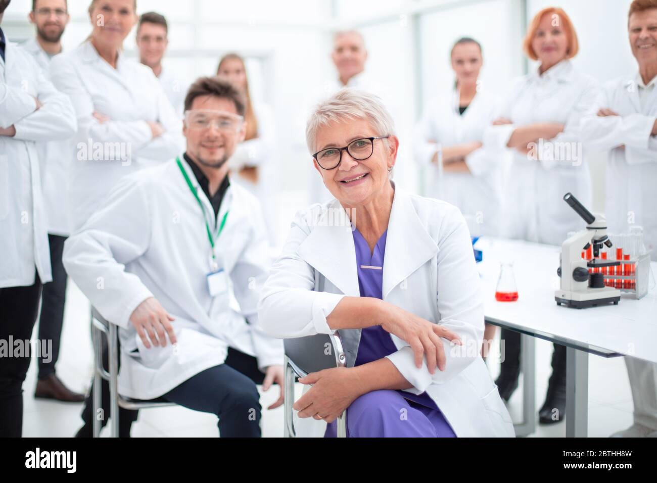 research supervisor and a group of young scientists in the workplace ...
