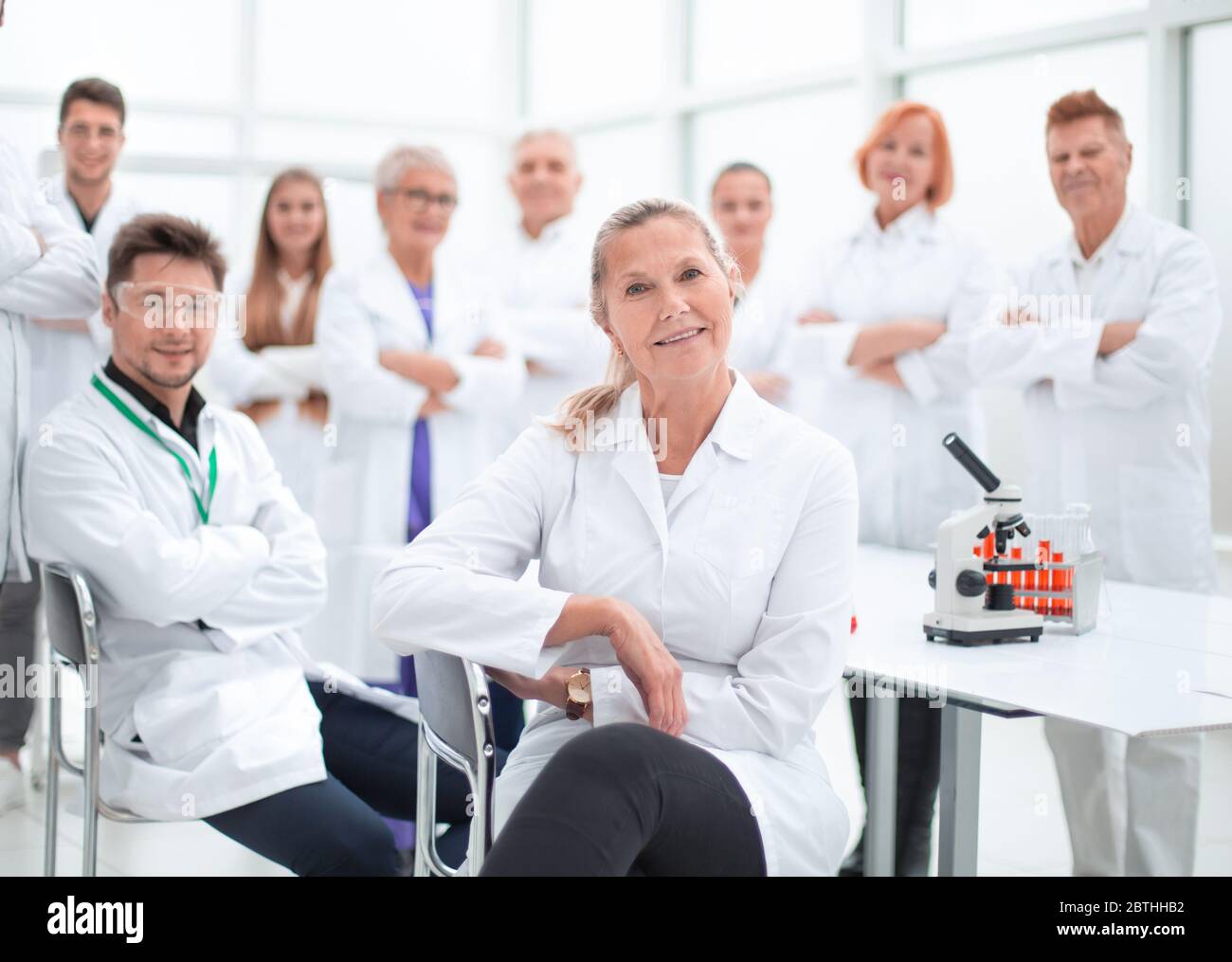 research supervisor and a group of young scientists in the workplace ...