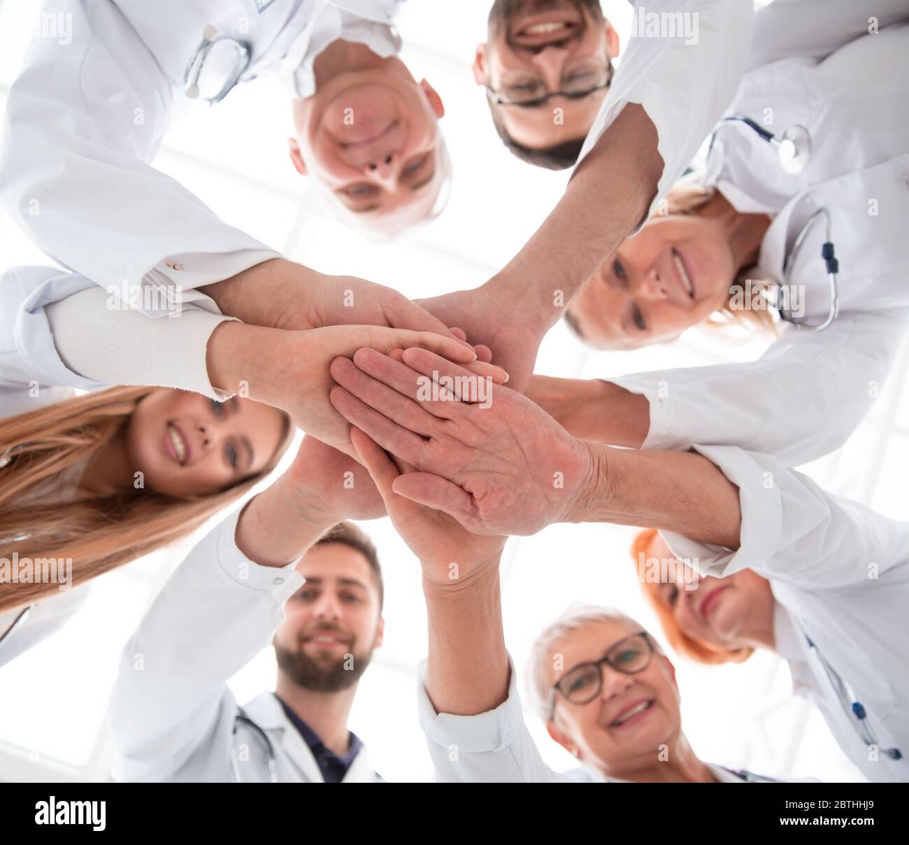 close up. group of different doctors putting their hands together Stock ...